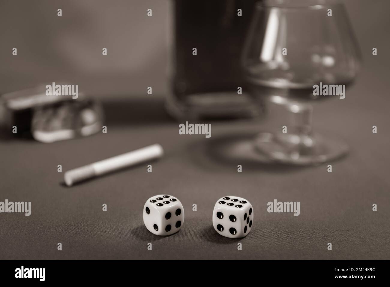 Dice double six, cigarettes and whiskey on table. selected focus, black ...