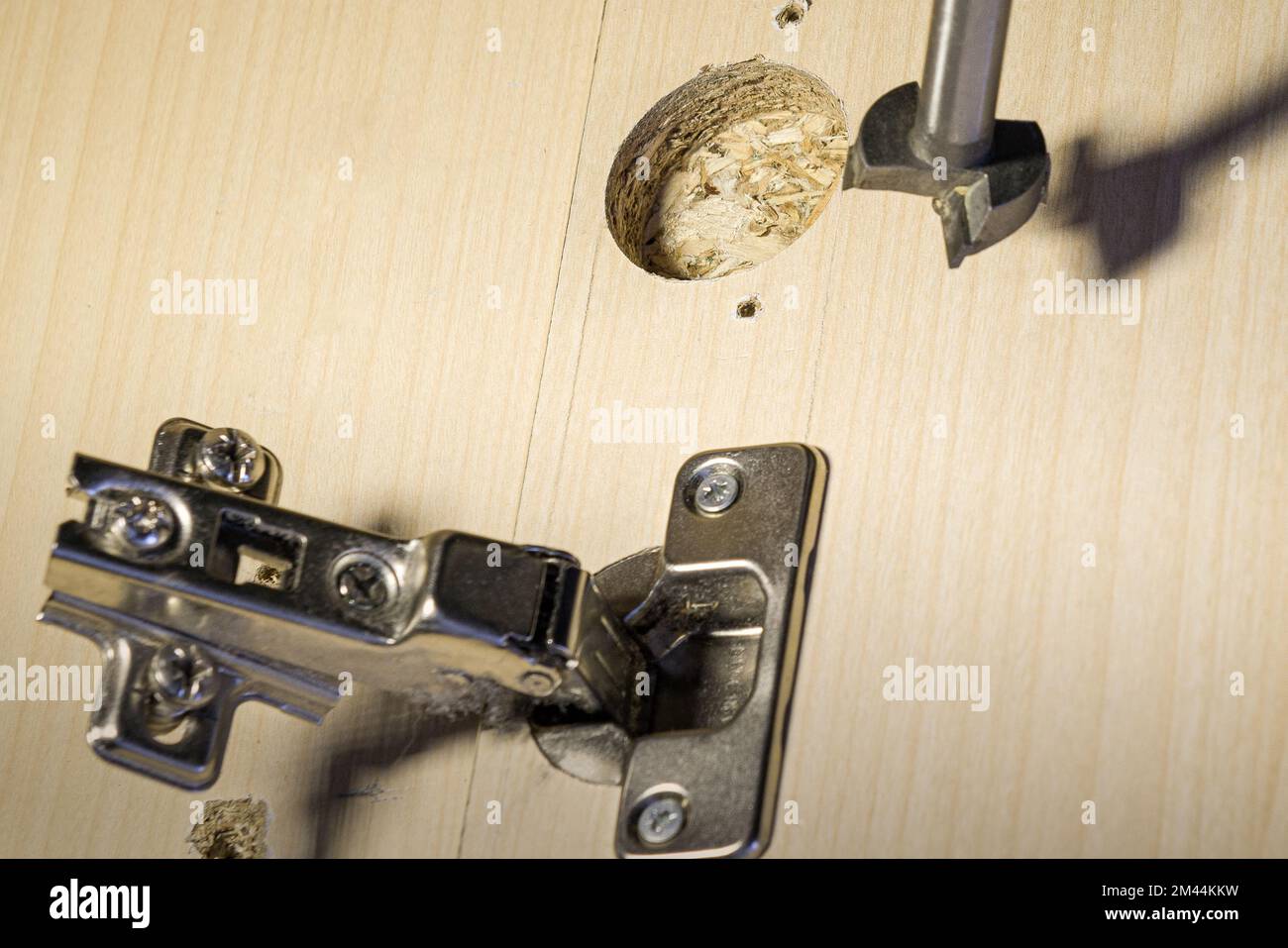 Repair and change new furniture fittings. hinge fixed on a modern ...