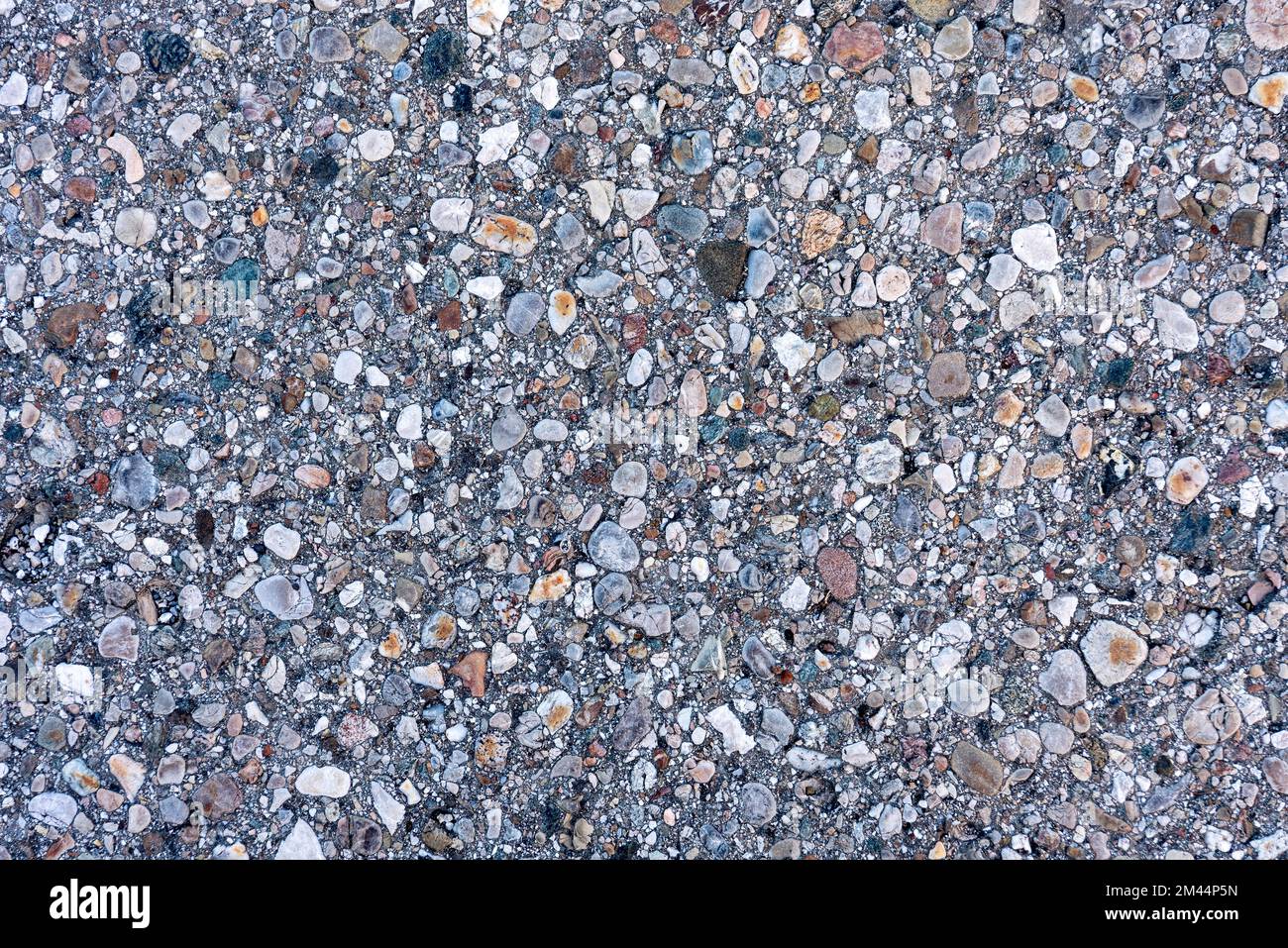 Asphalt road surface, enclosed colourful pebbles, grainy, pattern ...