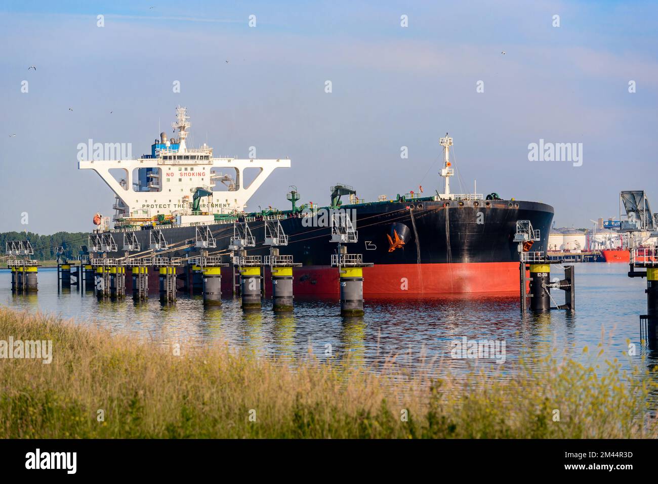 Large crude oil tanker ship moored in harbour at sunset Stock Photo - Alamy
