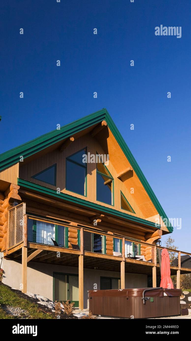 Back view of two story A-frame style log home with panoramic windows ...