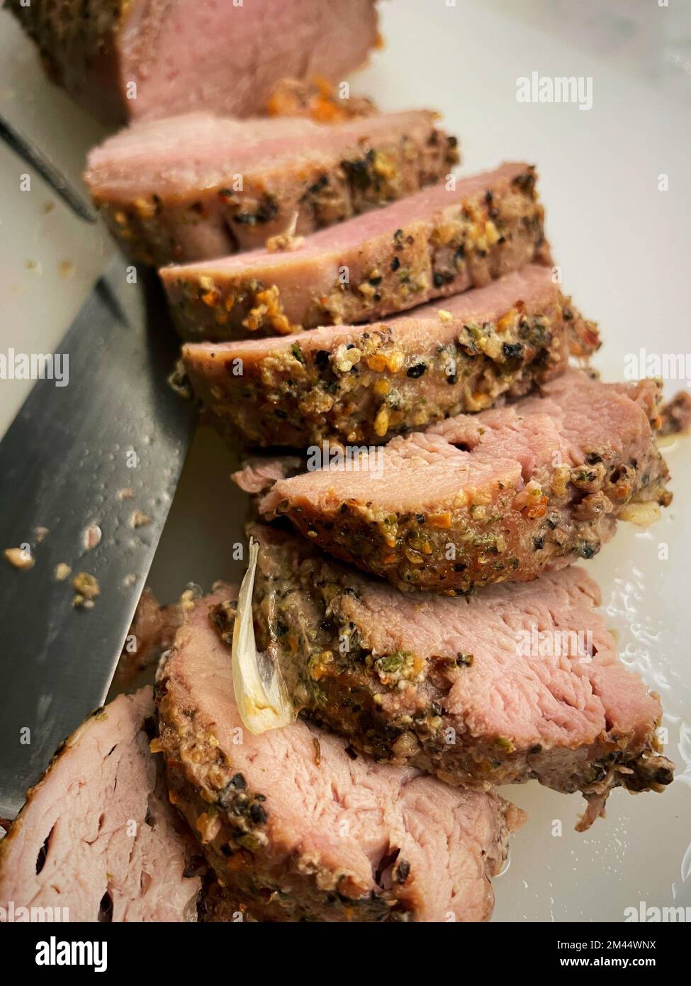 Is sliced pork tenderloin a wheat serving on a cutting board in a ...