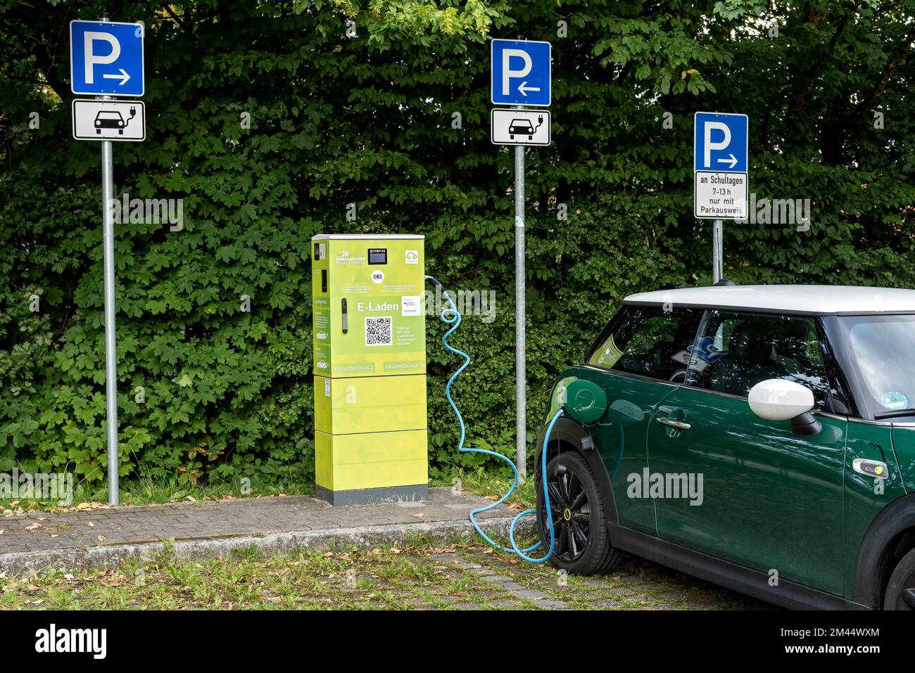 Car park with charging station, car, mini, electric car is charged at ...