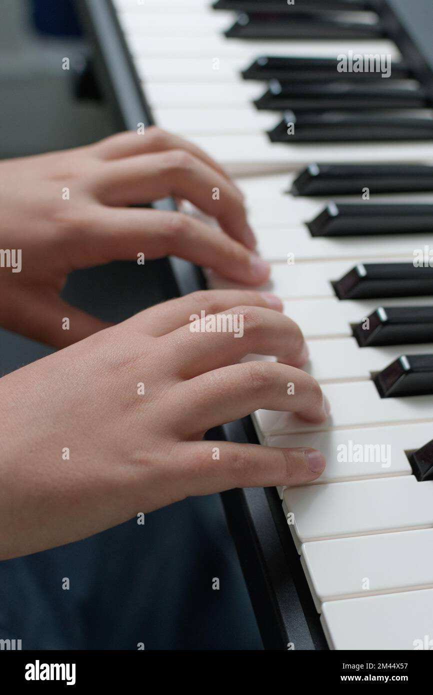 Music lessons. Two hands piano playing exercises. Keyboard close-up ...