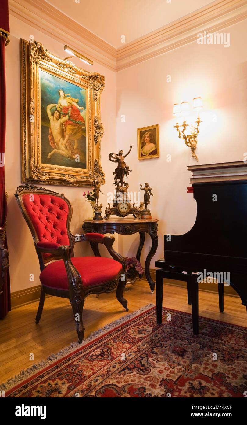 Antique furniture and furnishings including a piano adorn a music room ...