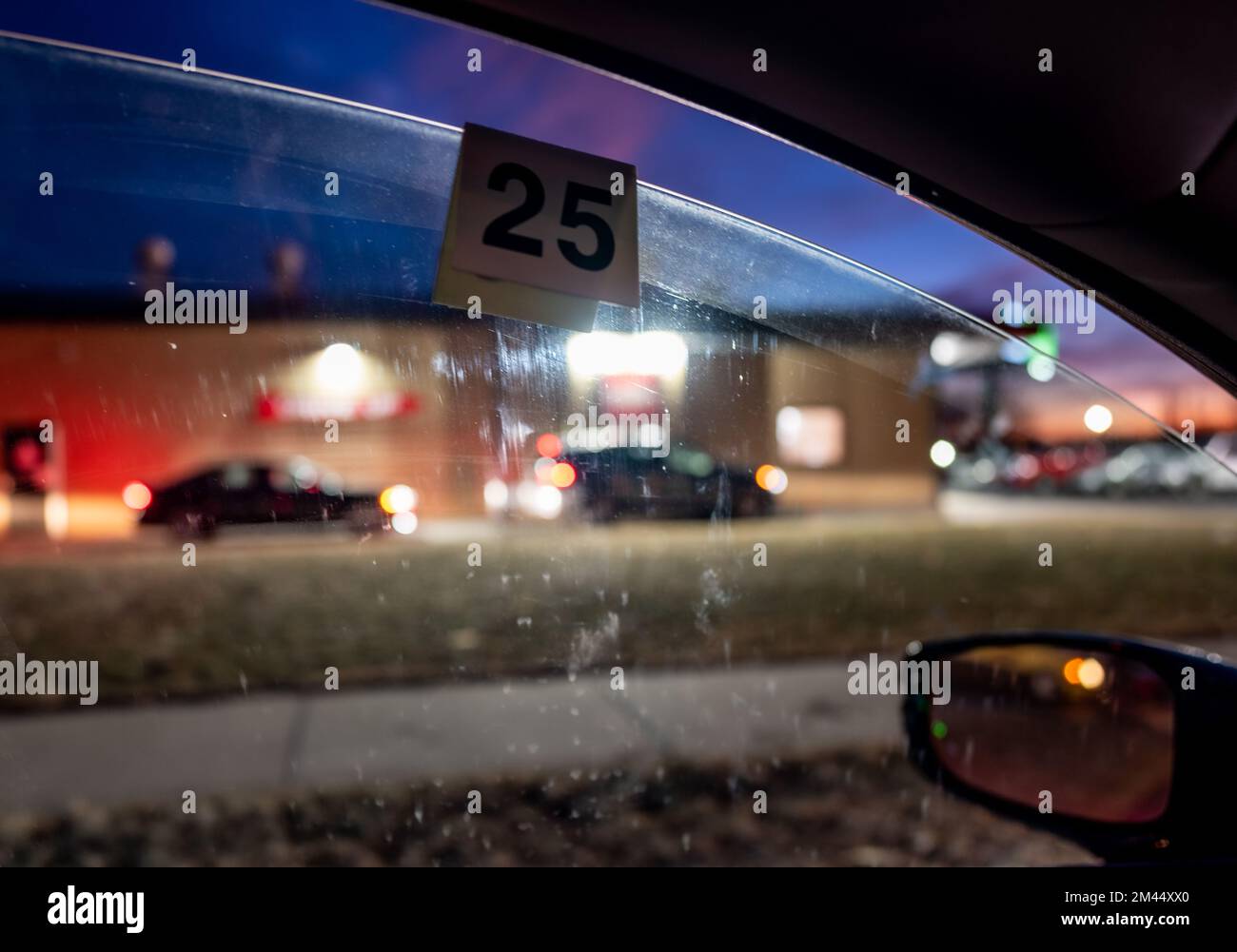 Fast food order number tag hanging on vehicle window with car line and ...