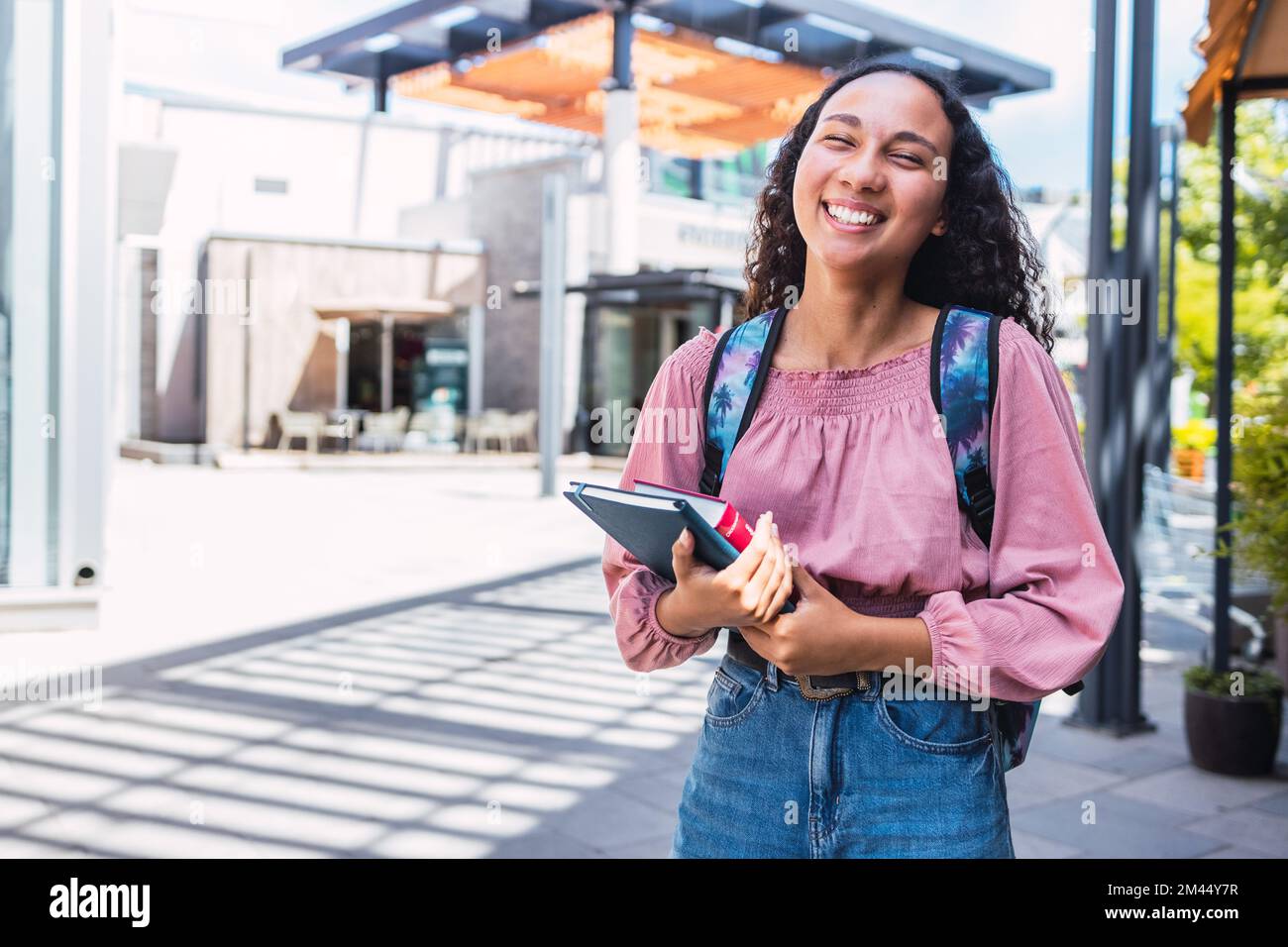 Confidence. Smiling latin university student woman standing and holding ...