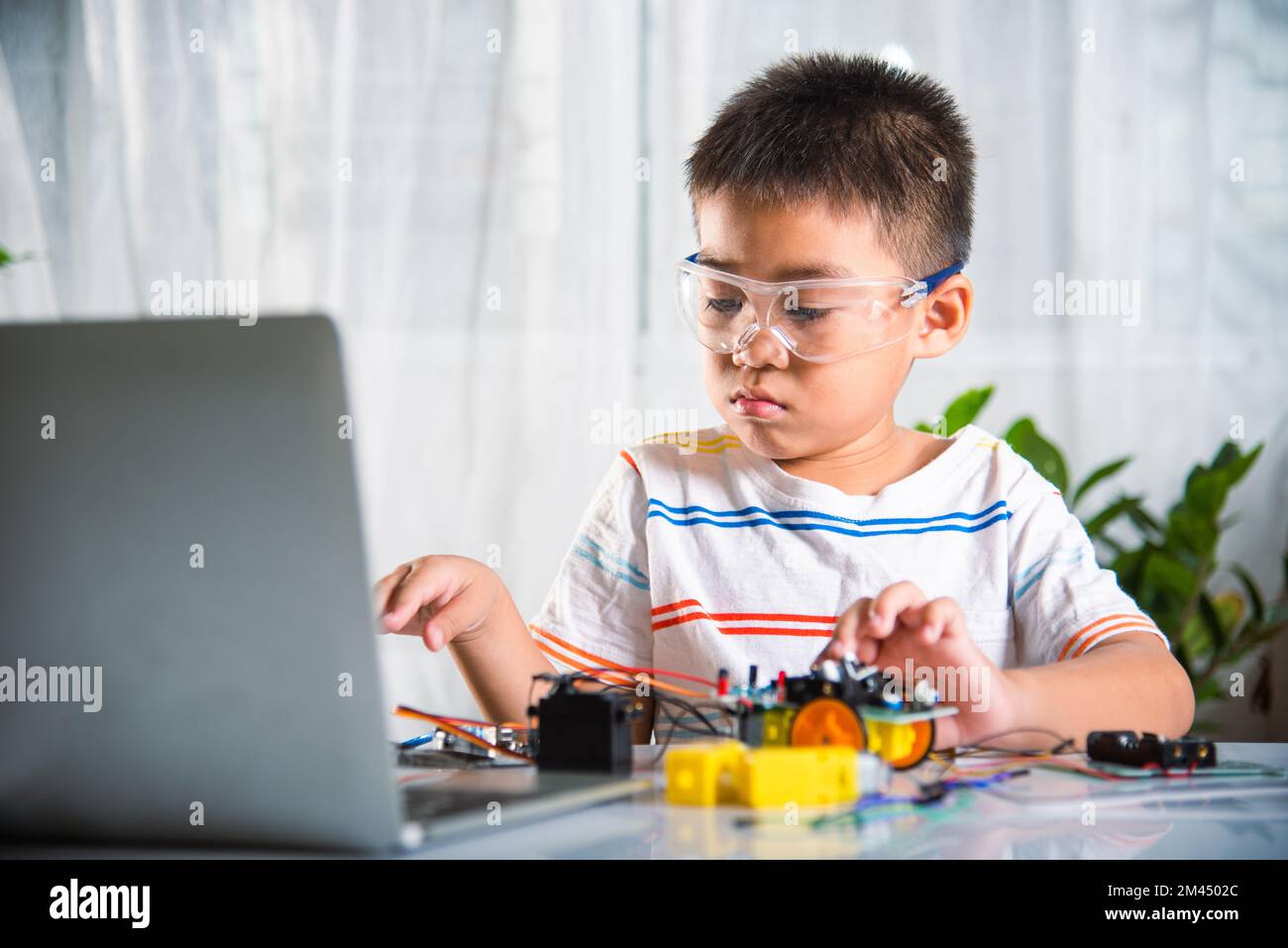 Little child trying assemble build wheel to car toy Stock Photo - Alamy