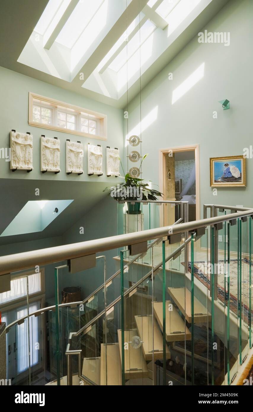 Second floor hallway with glass and metal staircase inside contemporary ...