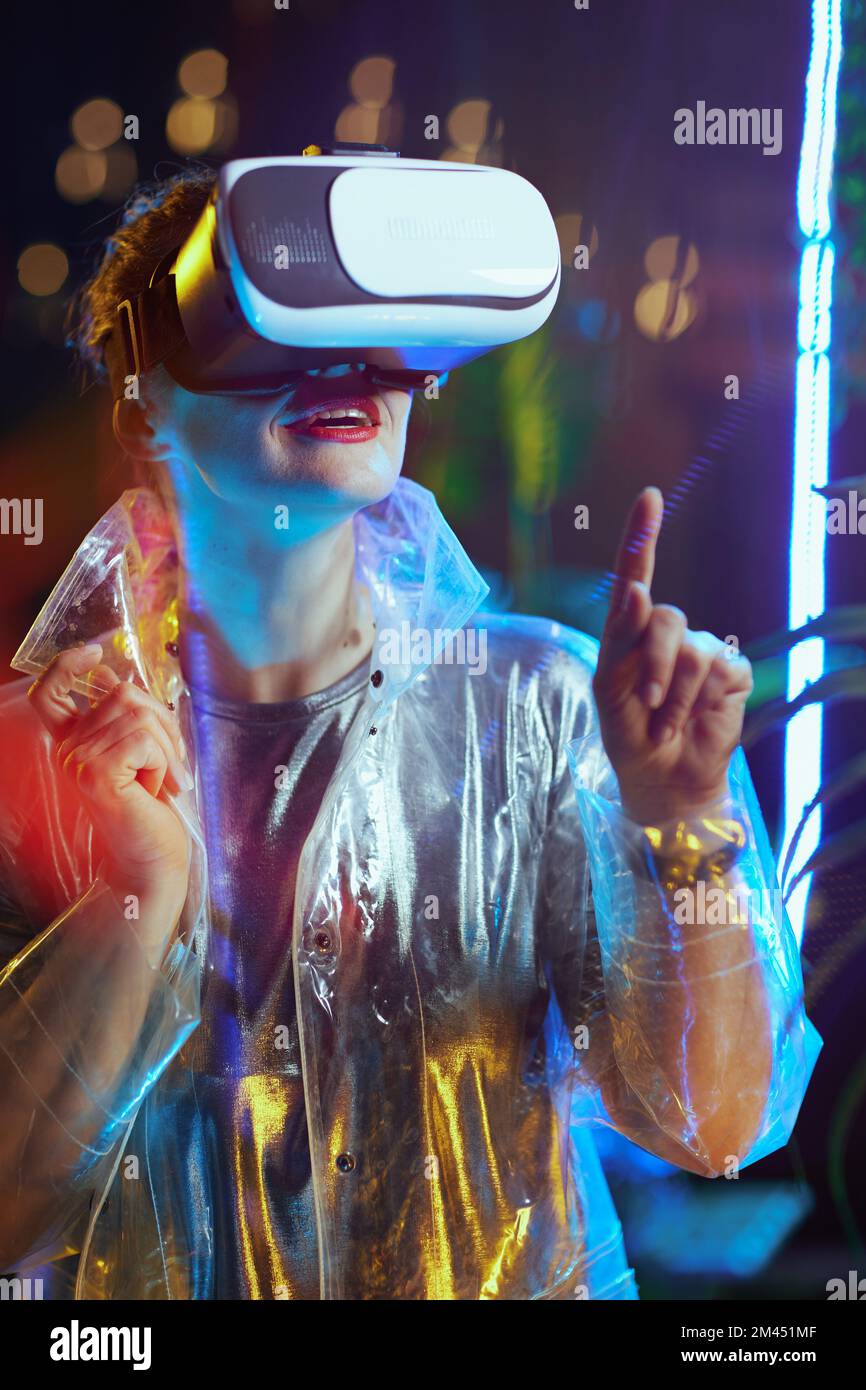 happy trendy woman in virtual reality in vr headset pressing the button ...