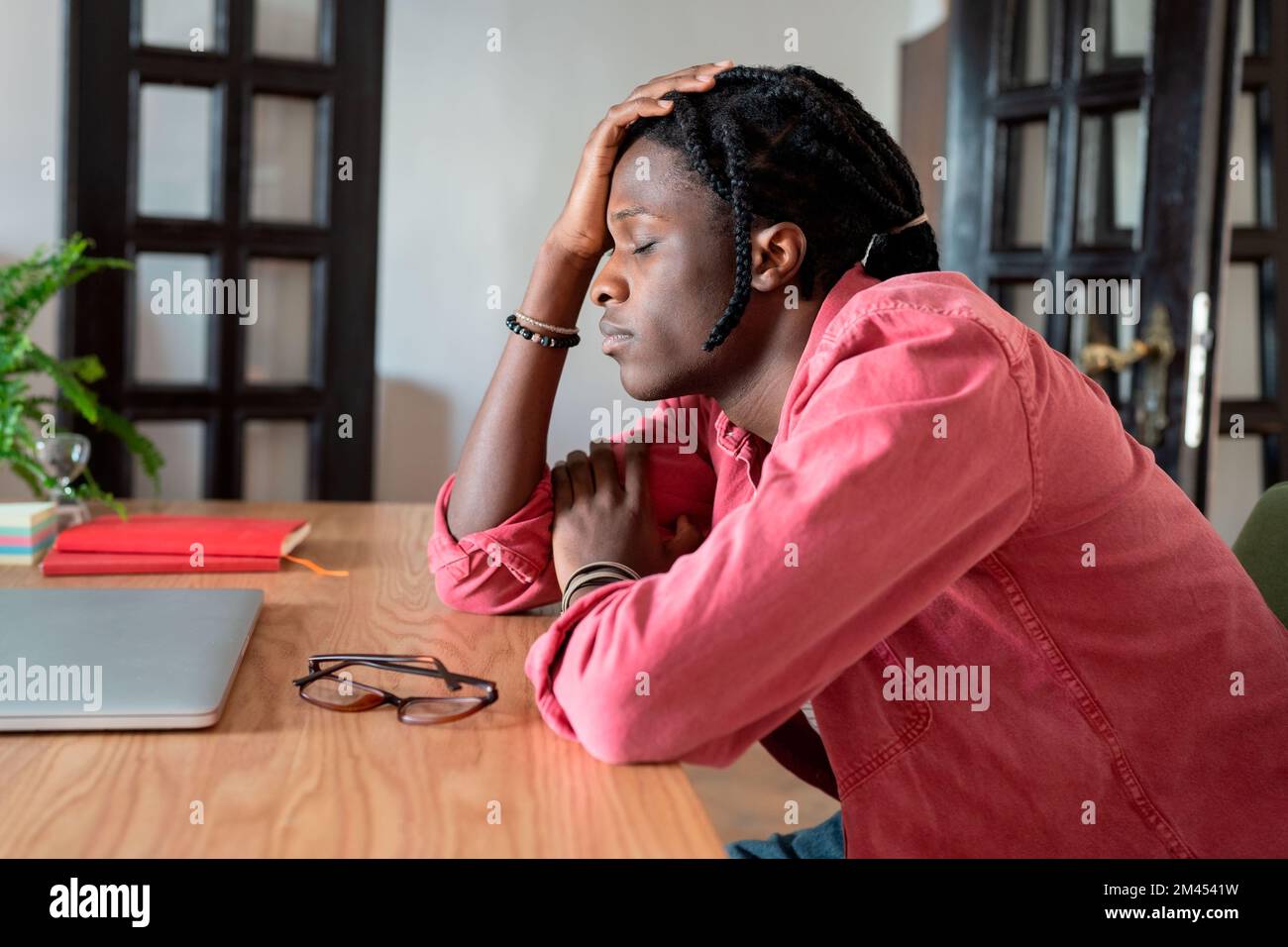 Exhausted overworked remote employee sitting with closed eyes at ...