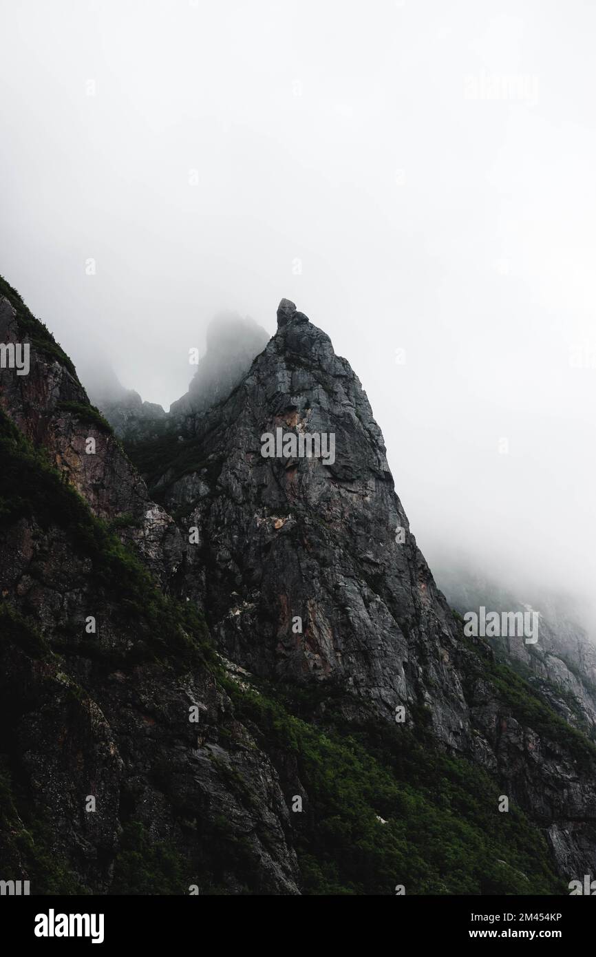 A vertical shot of cliff in a mist Stock Photo - Alamy