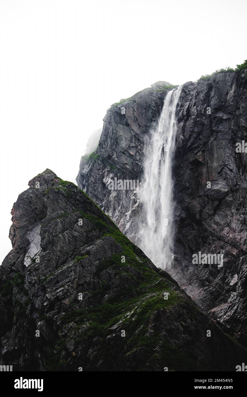 A vertical shot of waterfall dropping on rocky mountain in Western ...