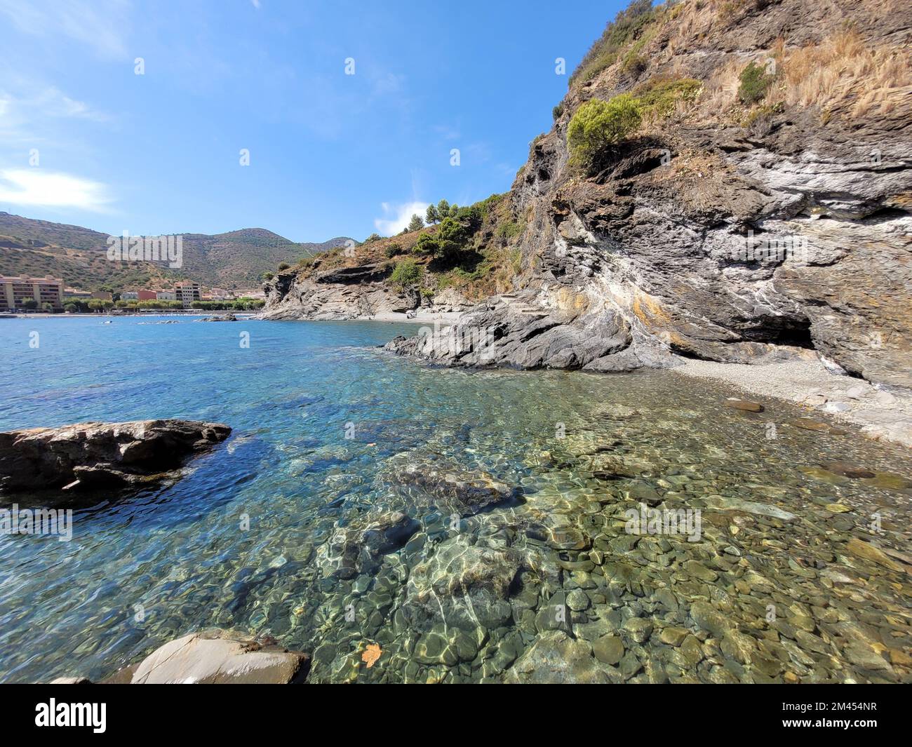 A beautiful shot of sea, rocky mountain and blue sky Stock Photo - Alamy