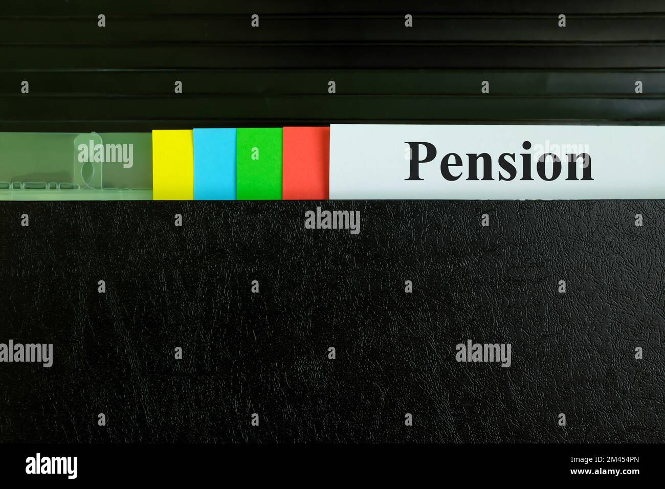 Hand picking pension file record in black binder folder. Pension ...