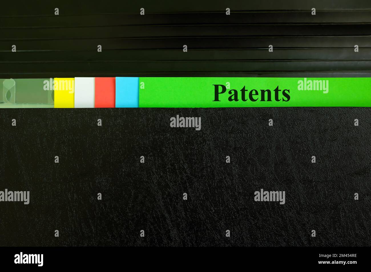 Hand picking patents file record in black binder folder. Patent and ...