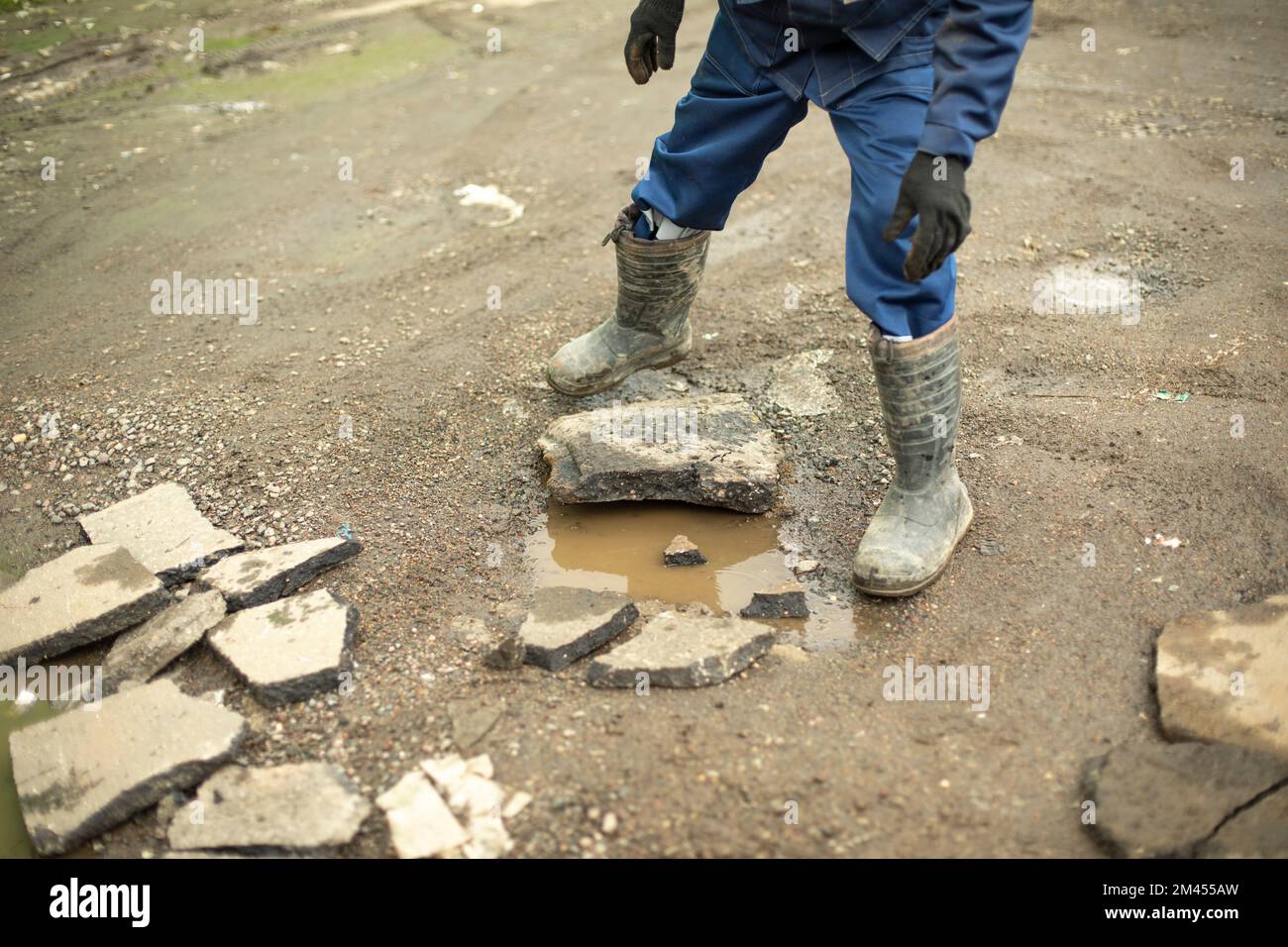 Worker carries stone. Cleaning of construction waste. Broken stone. Man ...