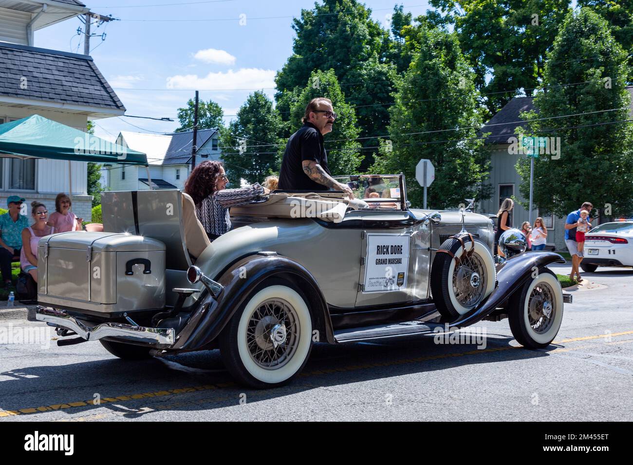 An antique beige Auburn convertible carries Grand Marshal Rick Dore in ...