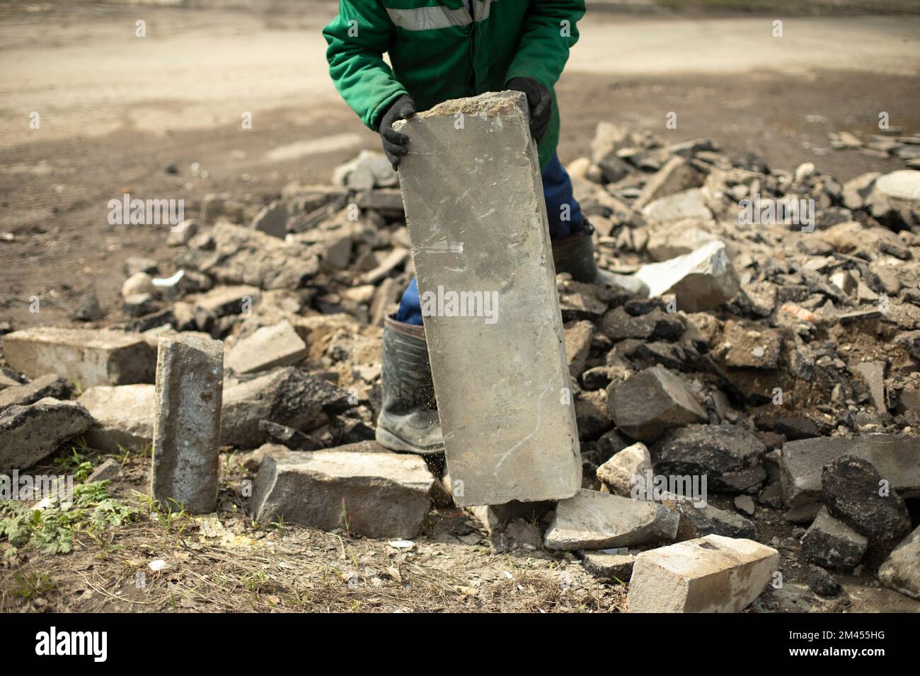 Worker takes broken stone. Cleaning of construction waste. Repair of ...