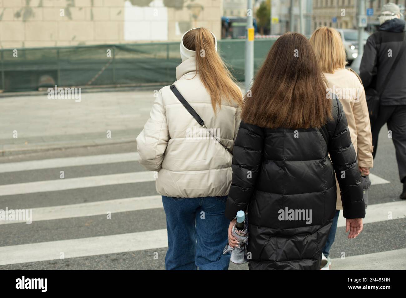 Girls walking on pedestrian crossing. Crossing road. People on street ...