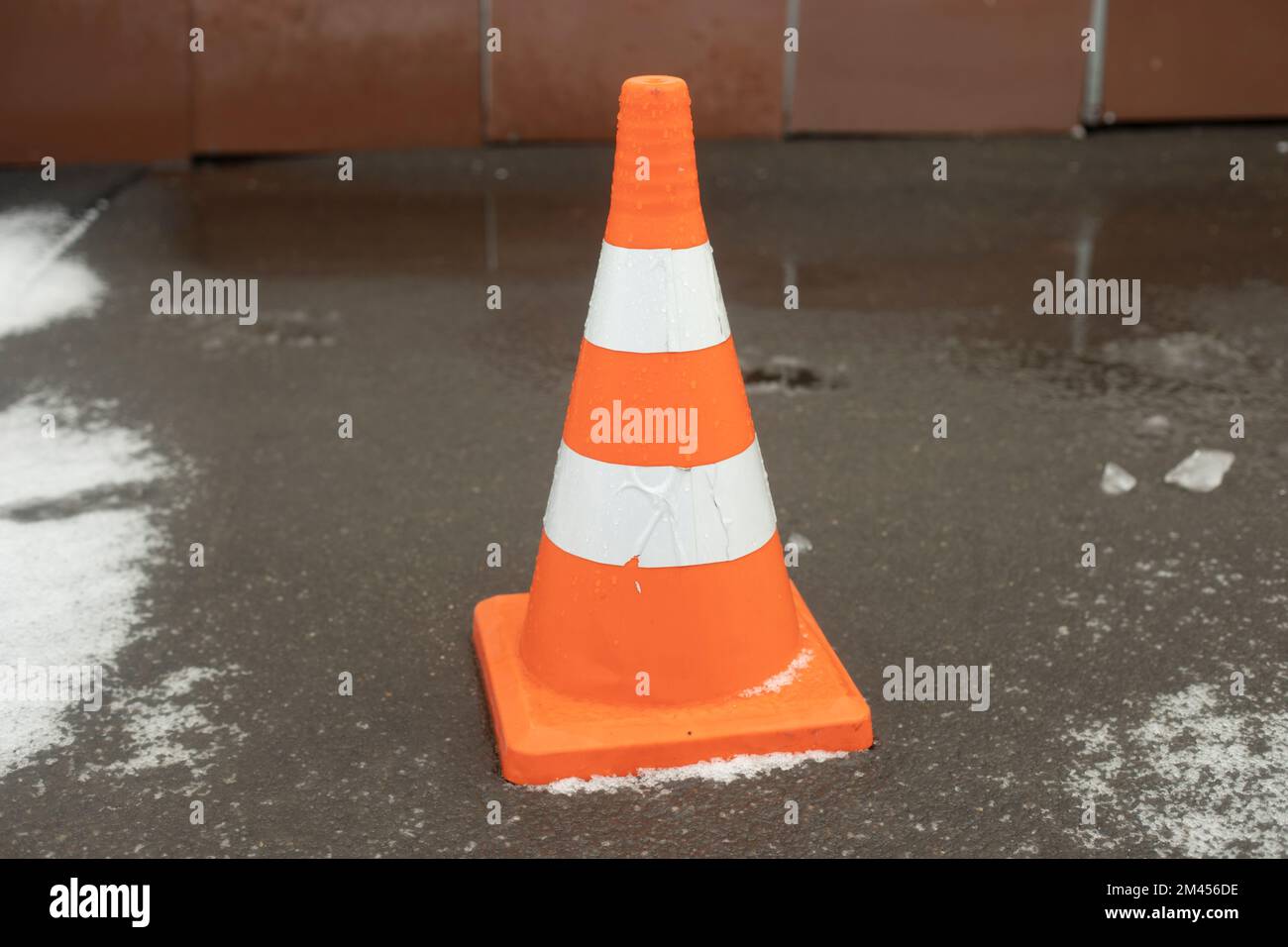 Orange cap on road. Warning signal. Motion limiter. Fenced area. Snow ...