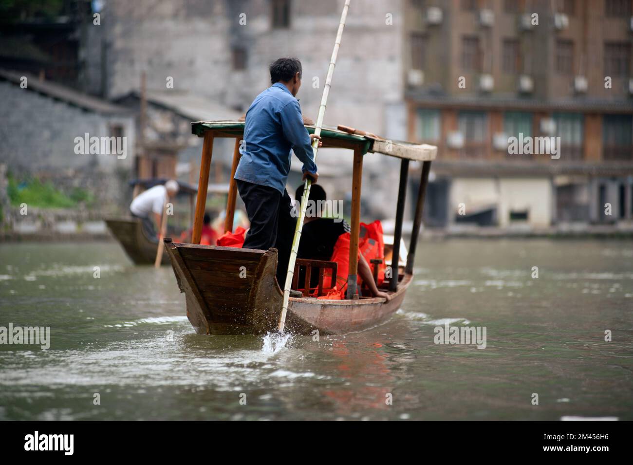 Tourists relax take a boat in the river at Fenghuang ancient city ...