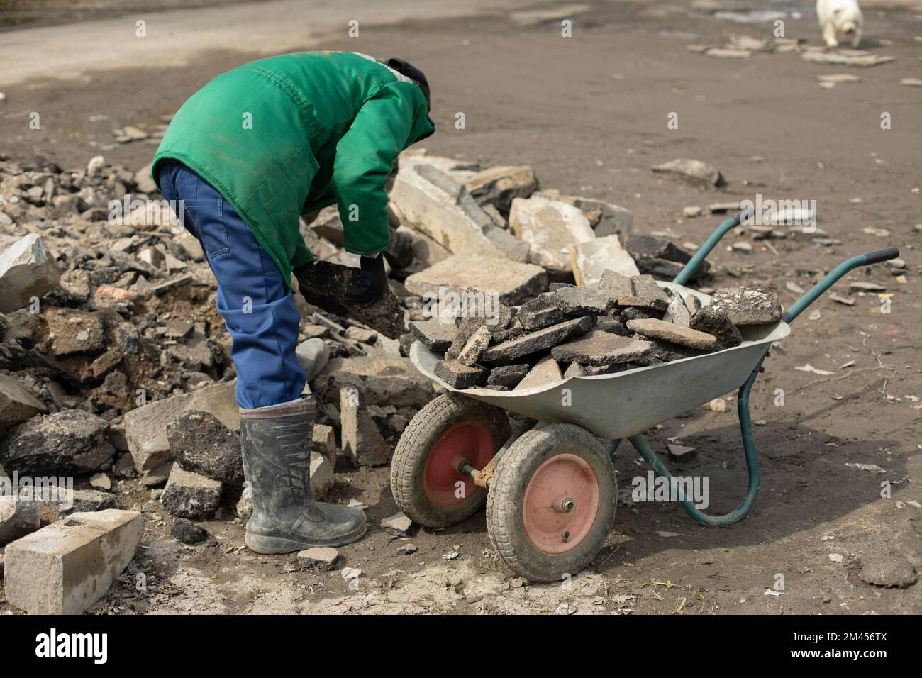 Transportation of broken stone. Worker dismantles block of stones ...