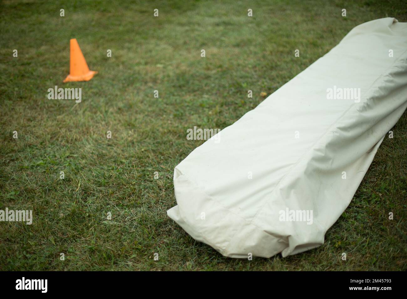 Sports equipment on lawn. Stadium details. Cover on long object. Fabric ...