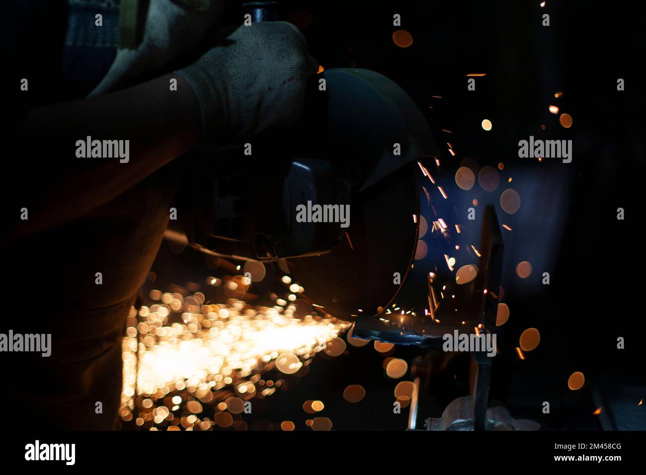 Metal sawing. Work on steel. Production details. Man cuts steel bar ...