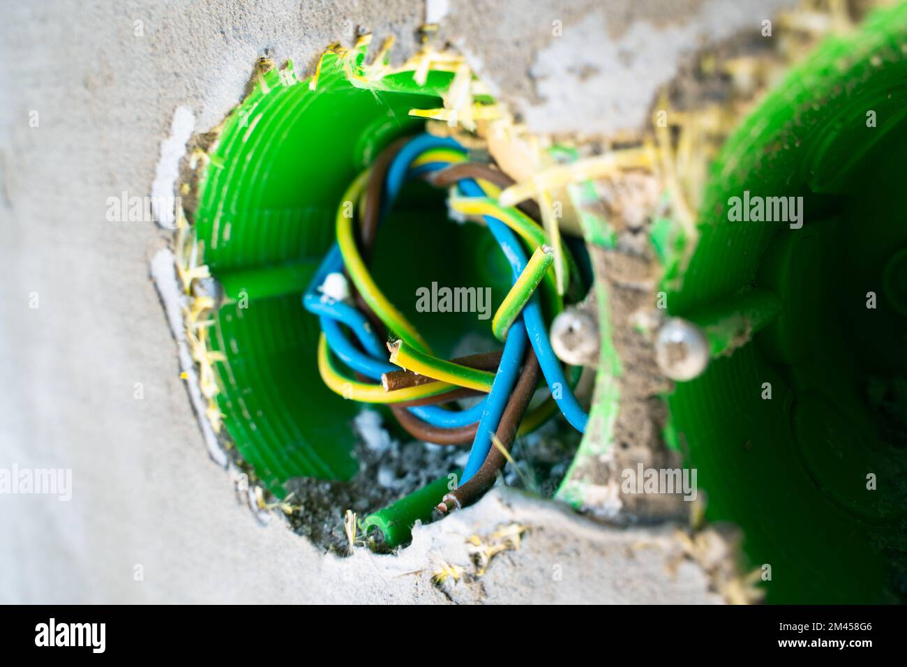Multi-colored wires in a green socket under the socket on the facade of ...
