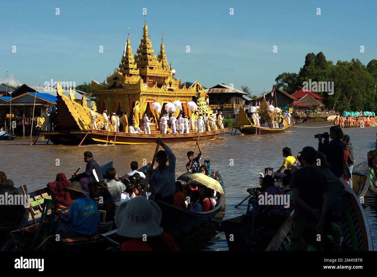 Peoples paddle by legs on the procession in Phaung Daw Oo Festival ,Inle lake ,Myanmar. The ...
