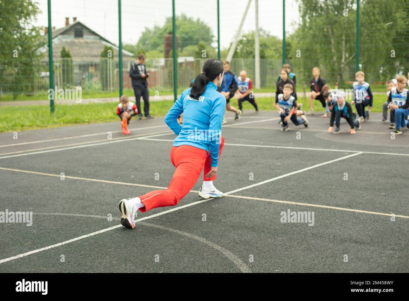 Coach shows children exercise. Playing sports on street. Fitness with ...