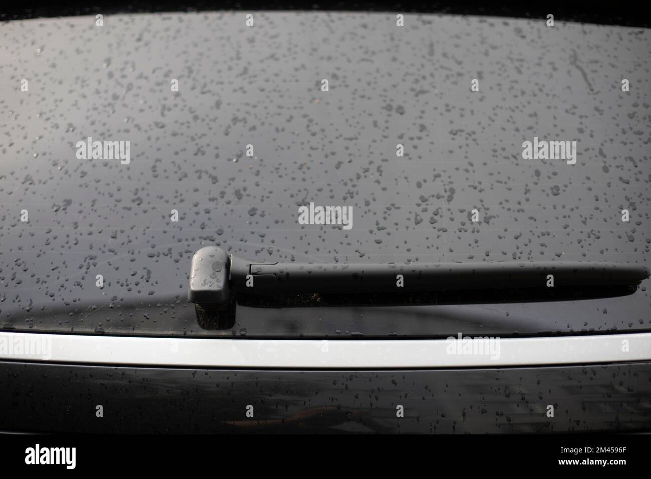 Wet car window. Rear window of transport. Drops on car. Building wiper ...