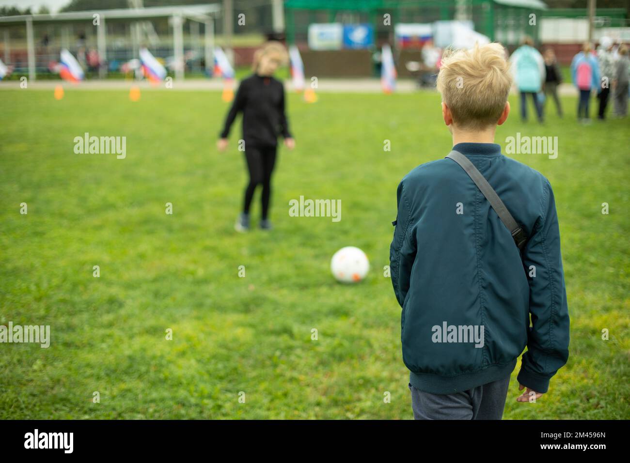 Children play ball on lawn. Schoolchildren on sports ground in summer ...