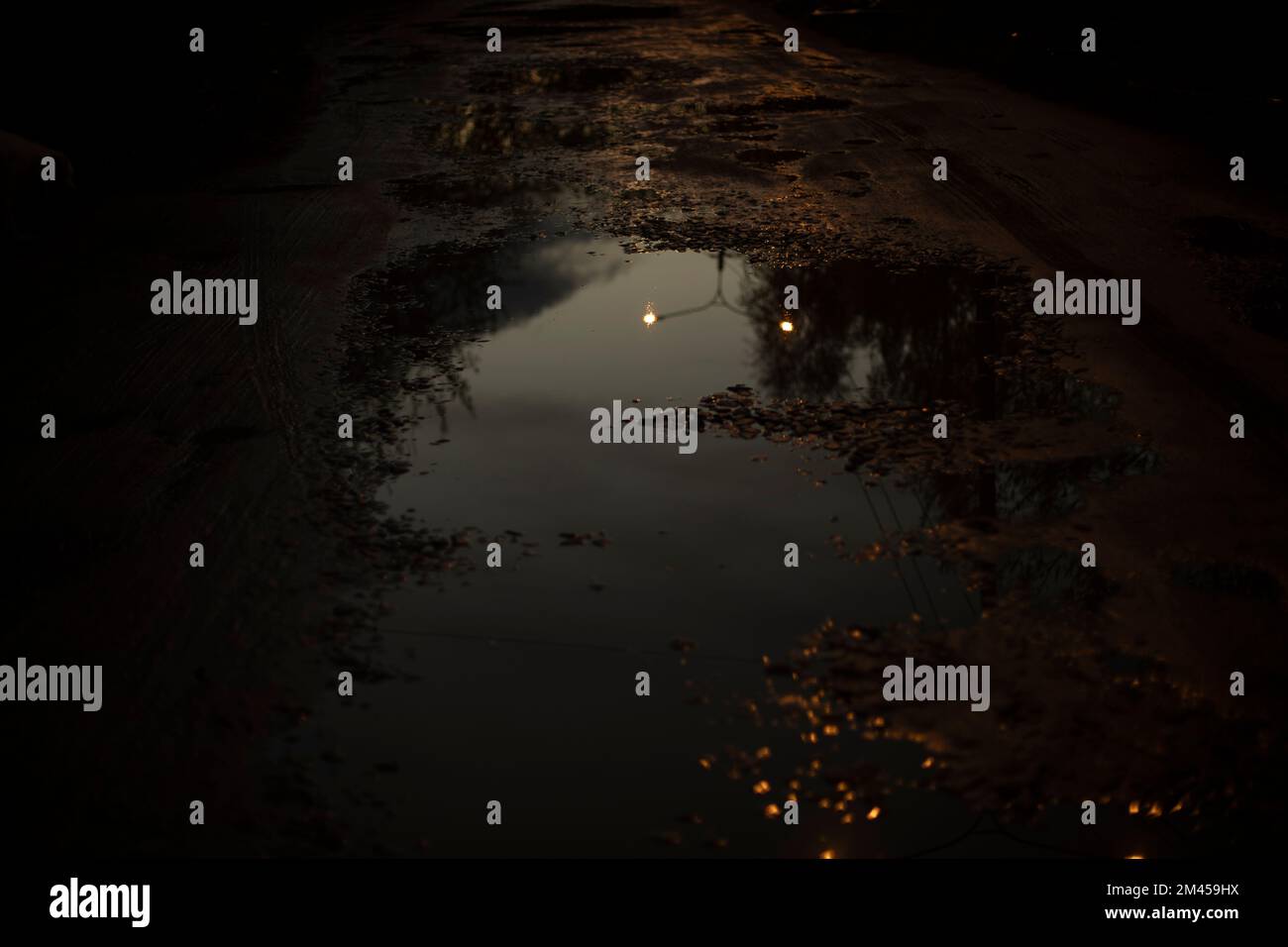 Large puddle in dark. Reflection of light in puddle. Bad road in Russia ...