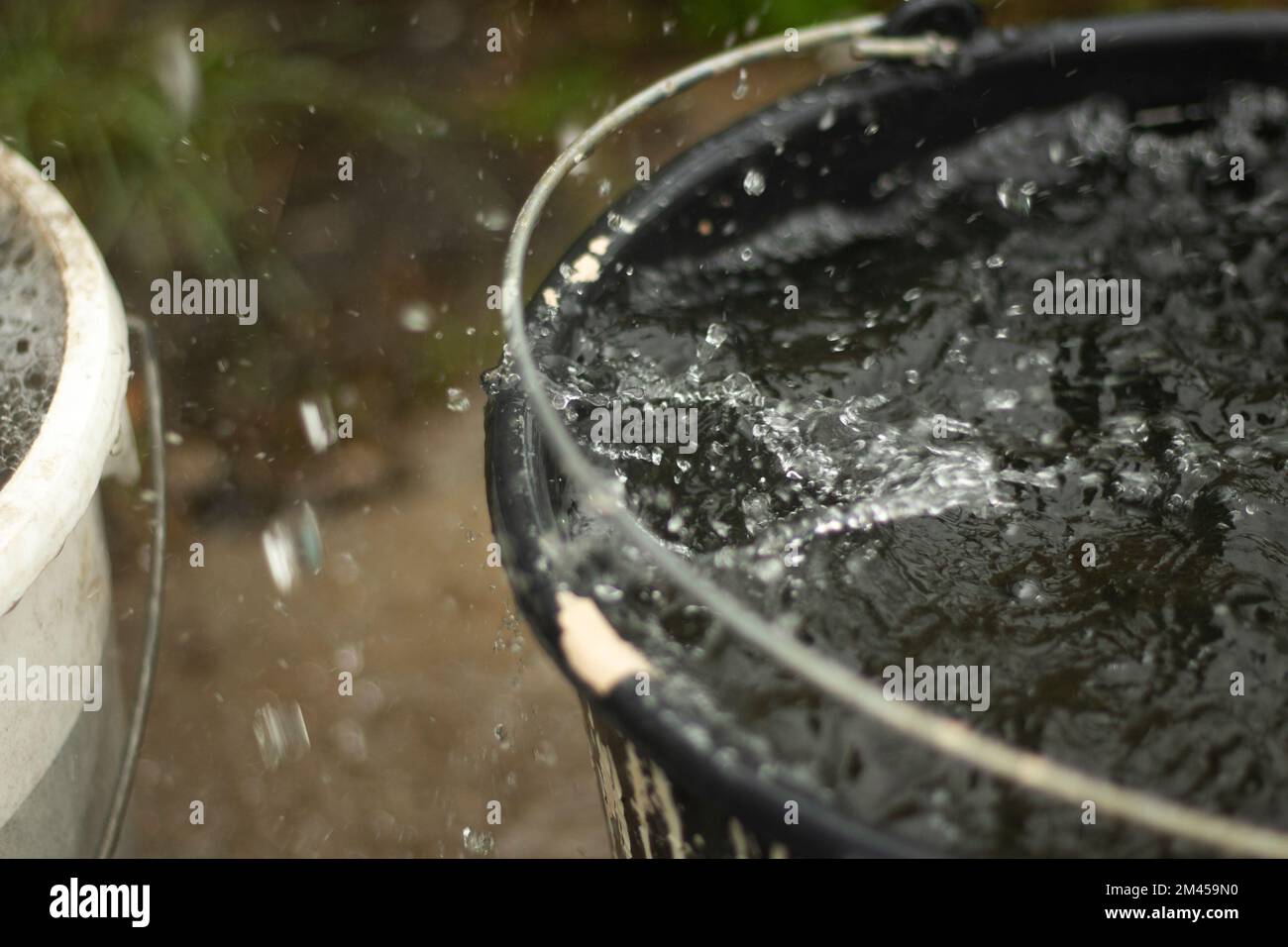 Rain is dripping into bucket. Water splashes in bucket. Details of rain ...
