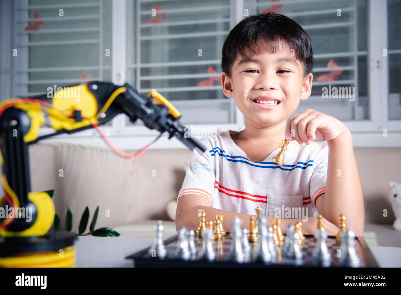 Asian little boy is playing chess with robot machine arm Stock Photo ...