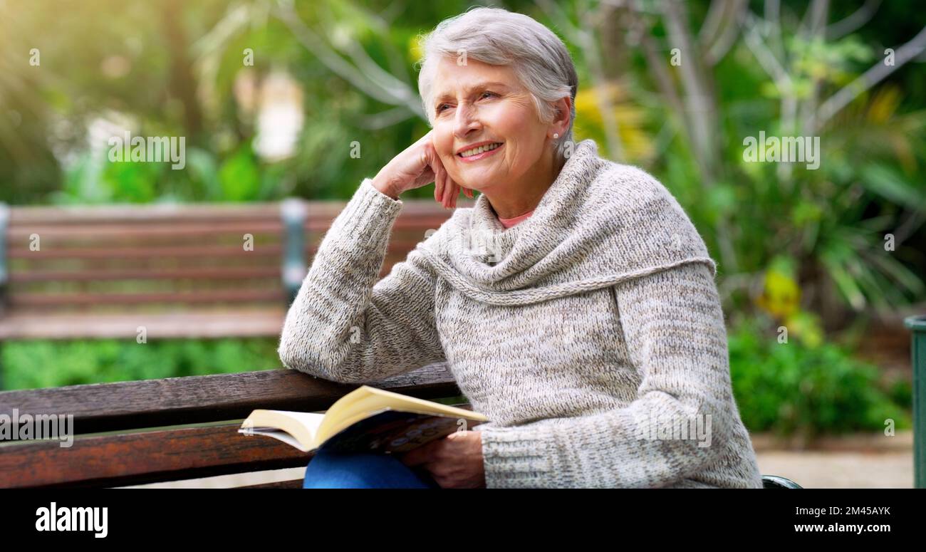 I love reading stories. a cheerful elderly woman reading a book by ...