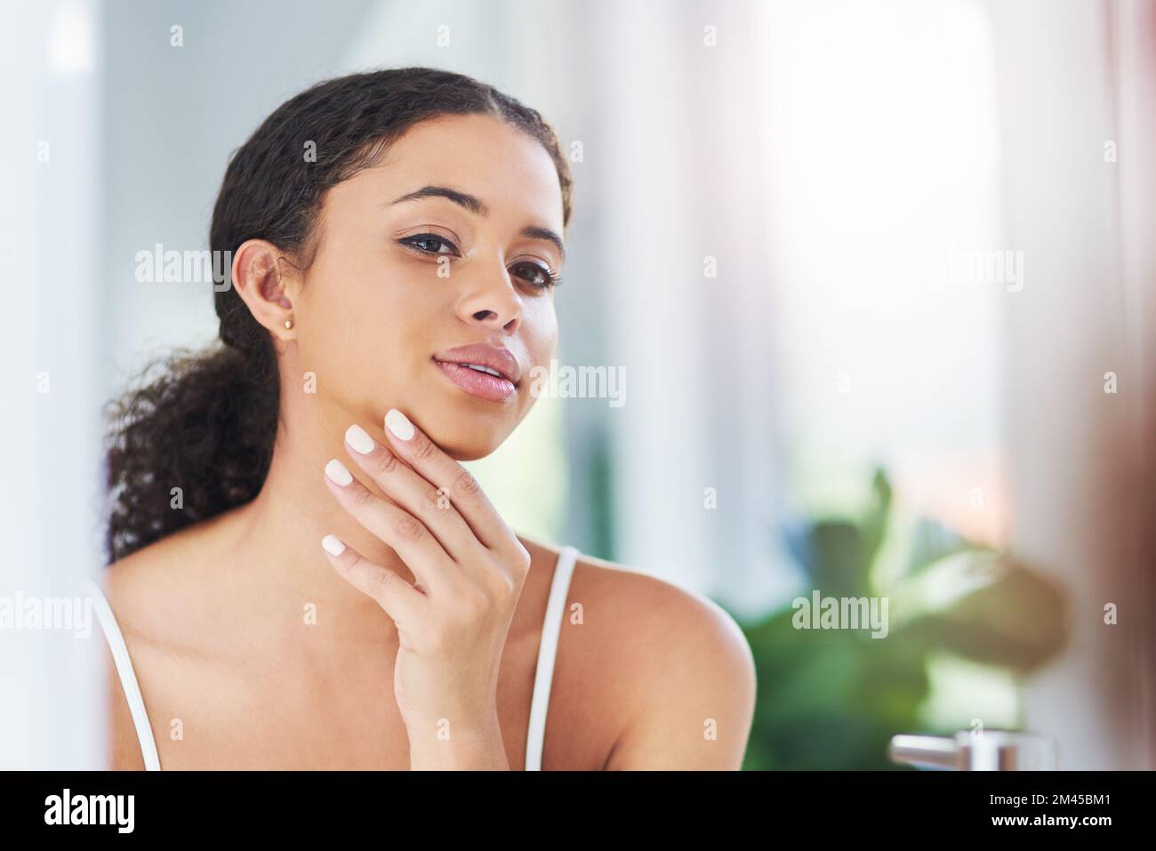 I dont see a spot in sight. an attractive young woman touching her face ...