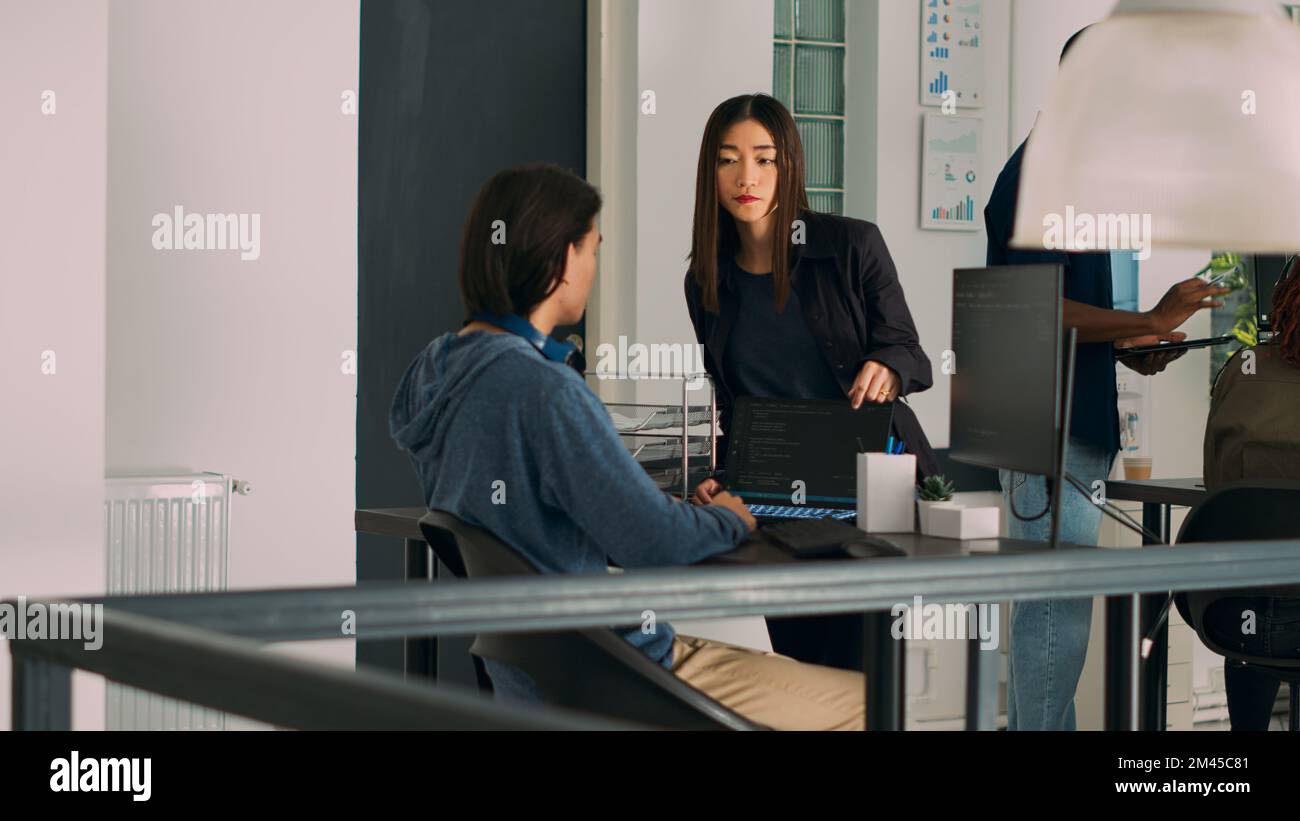 Team Of Database Admins Analyzing Source Code On Computer Monitor Comparing Data Script In Busy