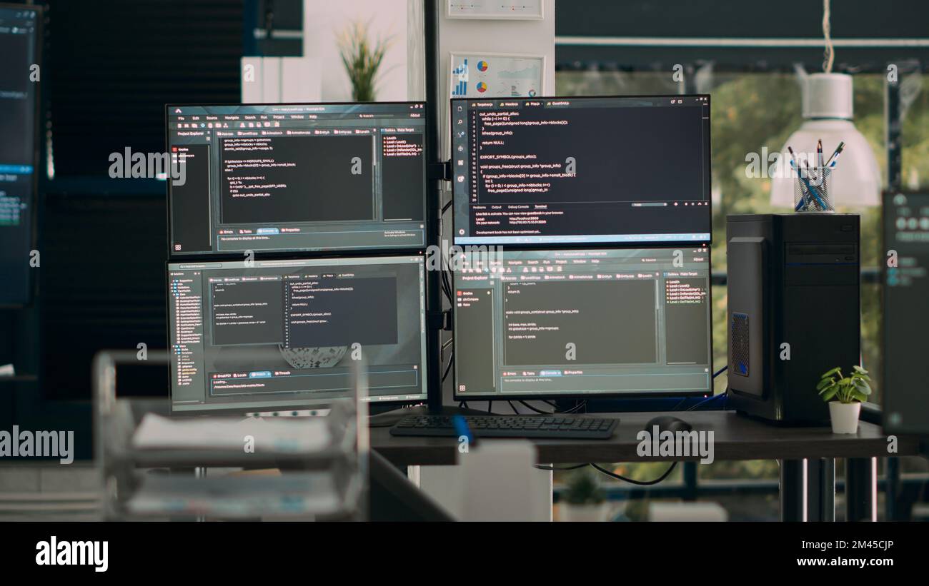 Empty office desk with multiple screens running software developing ... Empty office desk with multiple screens running software developing ...