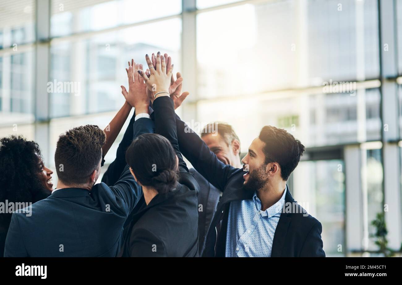 Lets raise the bar. a group of businesspeople forming a huddle with ...
