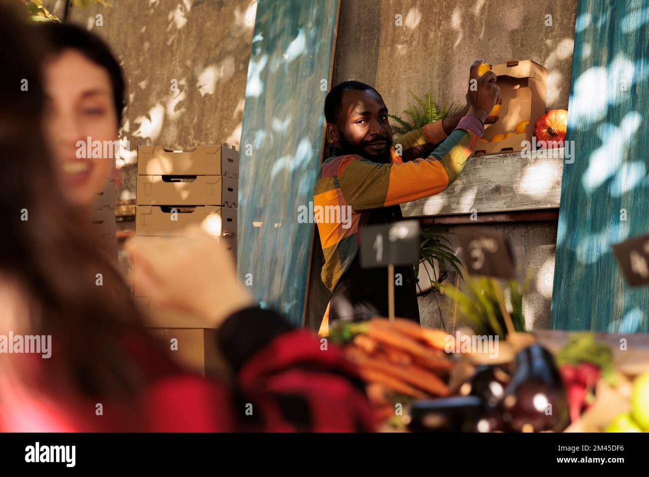 African american farmers market seller carrying lemons in hands and ...