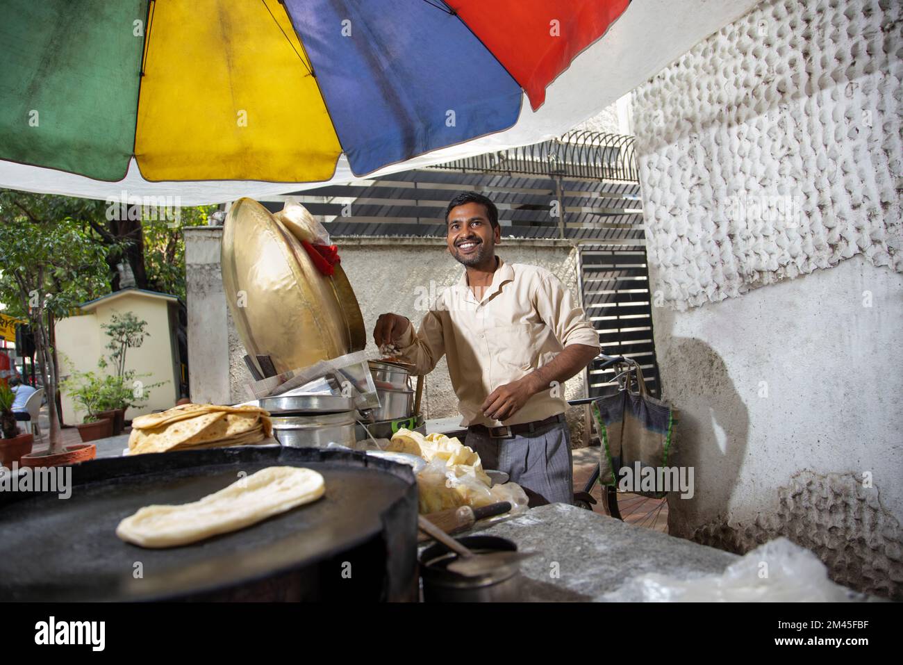 Portrait of a smiling male vendor at a roadside stall Stock Photo - Alamy