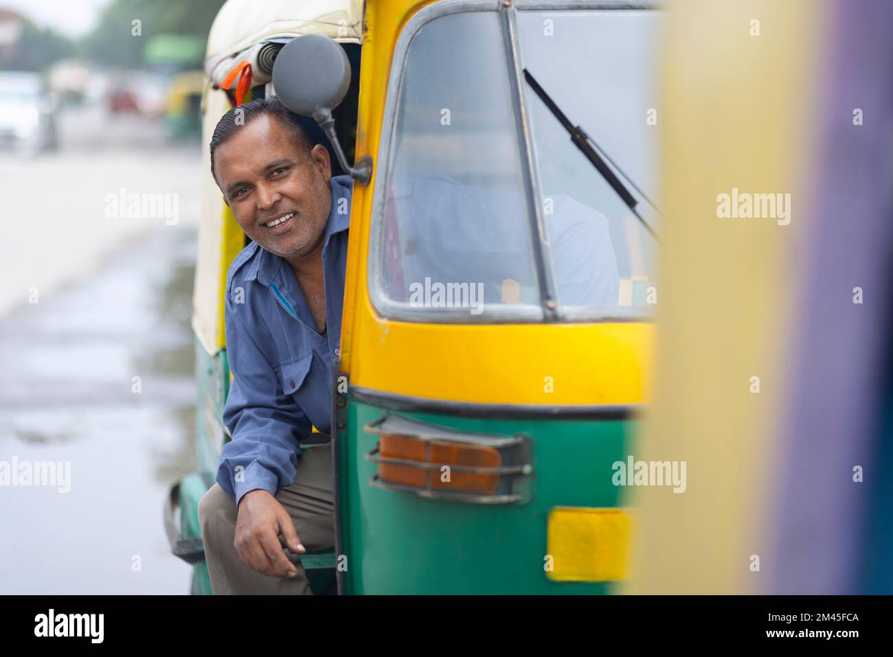 Portrait of a happy auto rickshaw driver sitting Stock Photo - Alamy