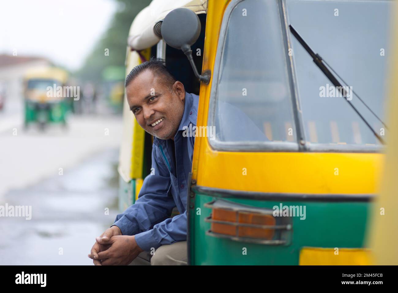 Portrait of a happy auto rickshaw driver sitting Stock Photo - Alamy