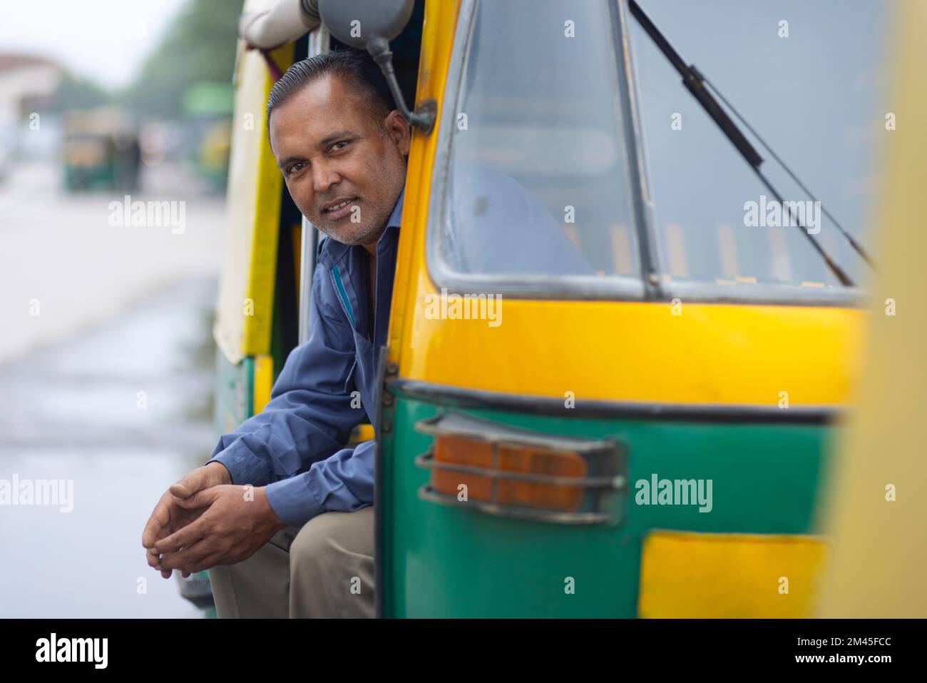 Portrait of a happy auto rickshaw driver sitting Stock Photo - Alamy