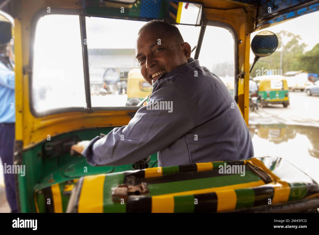 Portrait of an auto rickshaw driver looking back while driving Stock ...