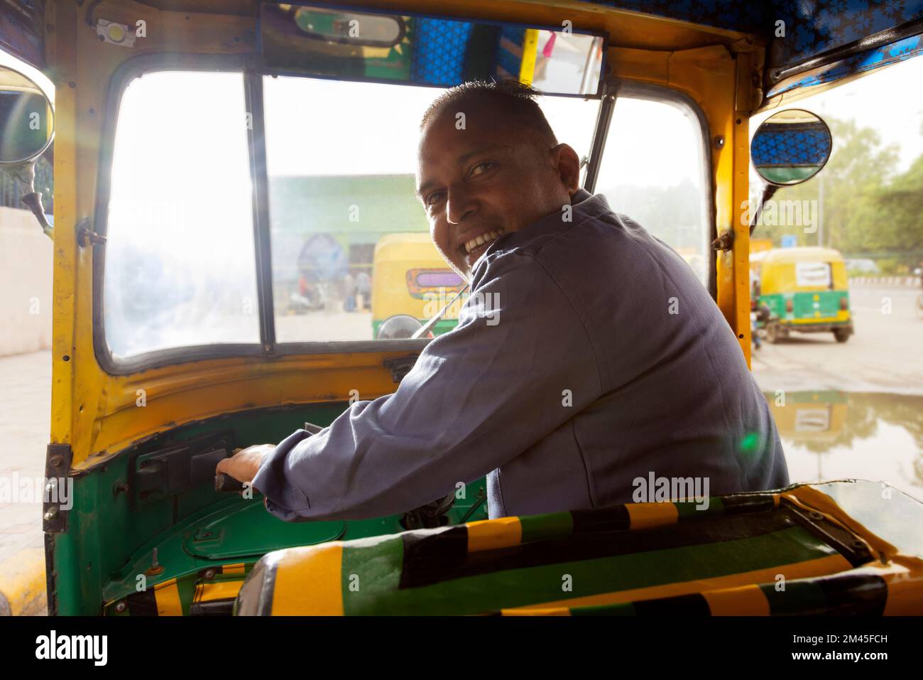 Portrait of an auto rickshaw driver looking back while driving Stock ...