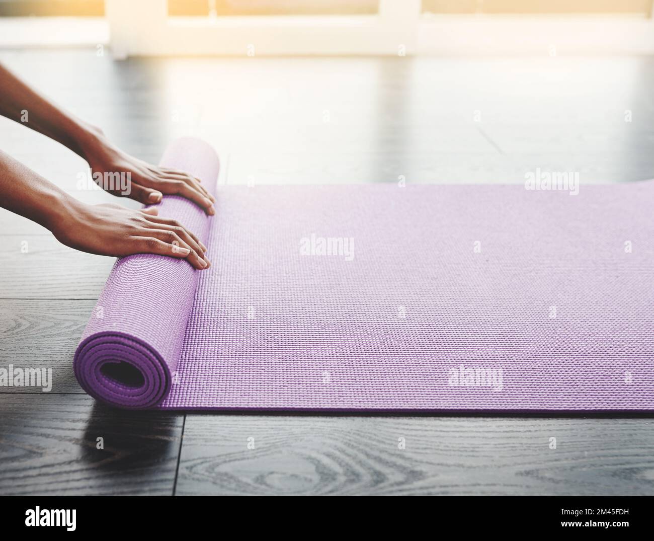 Make time for yoga. an unrecognizable woman rolling up her yoga mat ...